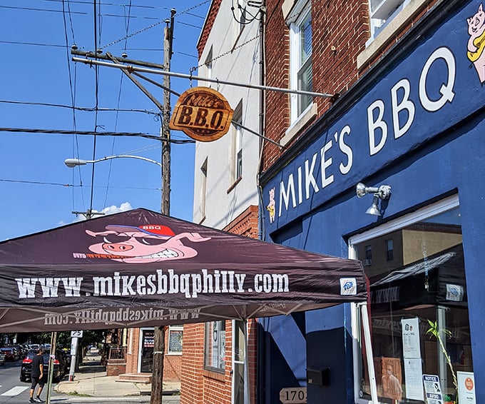 The blue storefront of Mike's BBQ stands out like a beacon for meat lovers, with its wooden sign promising smoky delights within the brick building.