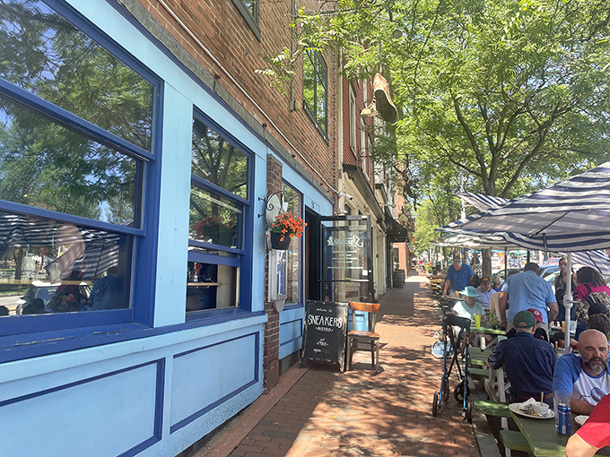 The bright blue storefront of Sneakers Bistro beckons like a culinary lighthouse on Winooski's brick-lined streets. Outdoor seating invites you to people-watch while savoring breakfast perfection.
