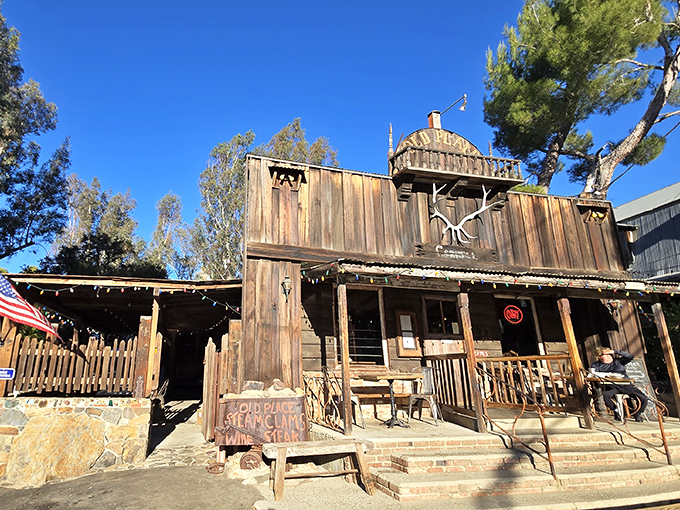 The Old Place stands proudly against the California sky, its weathered wooden facade a time capsule from the Wild West era.