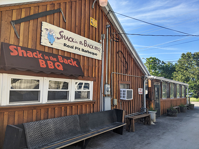 The rustic wooden exterior of Shack in the Back BBQ promises authentic flavors without pretense. That bench out front? It's for savoring the anticipation.