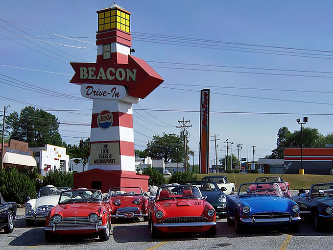 The iconic red arrow sign of The Beacon Drive-In stands tall against the Carolina sky, a lighthouse for hungry travelers and classic car enthusiasts alike.