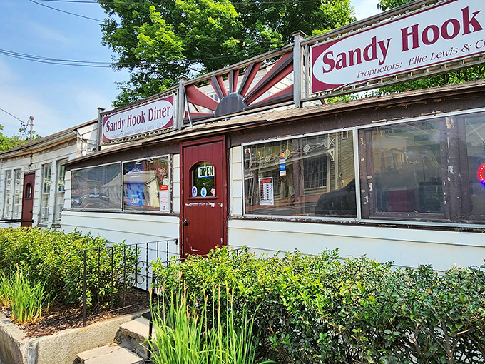 The classic roadside charm of Sandy Hook Diner beckons with its vintage sunburst sign and cozy exterior&mdash;a time capsule of Americana waiting to be discovered.