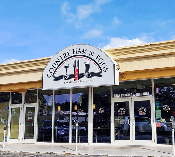 Morning sunshine glints off the iconic Country Ham N' Eggs sign, where Fort Lauderdale locals and road-tripping breakfast enthusiasts converge for their daily comfort food fix.