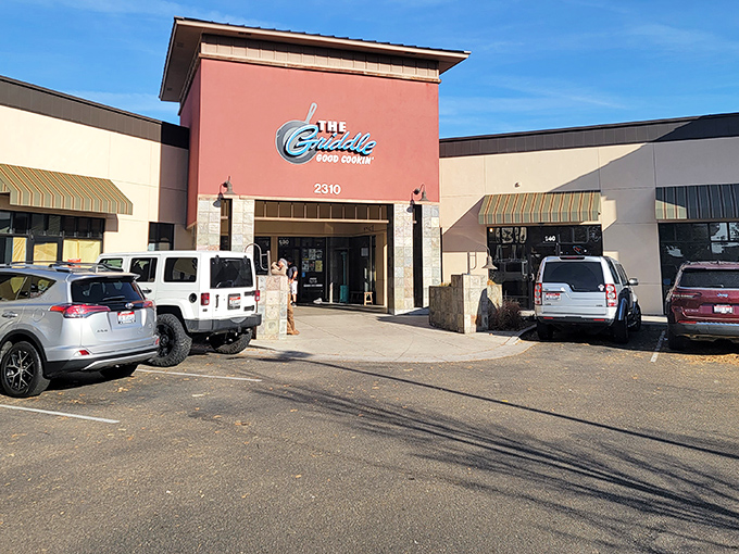 Parking lot filled with vehicles of breakfast pilgrims who know that weekend calories don't count, especially when they're this delicious. The salmon-colored facade stands like a temple to morning indulgence.
