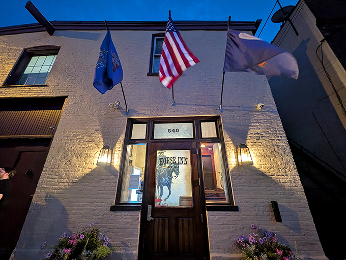 Three flags wave like a welcoming committee, telling you this place means business about hospitality.