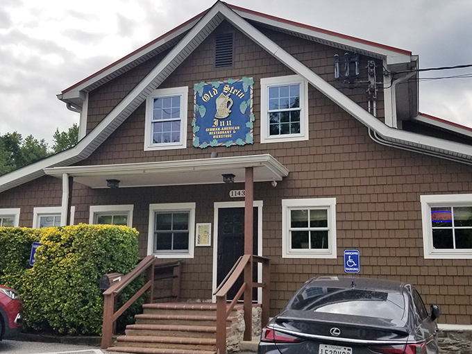 The charming cedar-shingled exterior of Old Stein Inn beckons like a Bavarian postcard come to life in suburban Maryland. That blue sign promises authentic German delights inside.