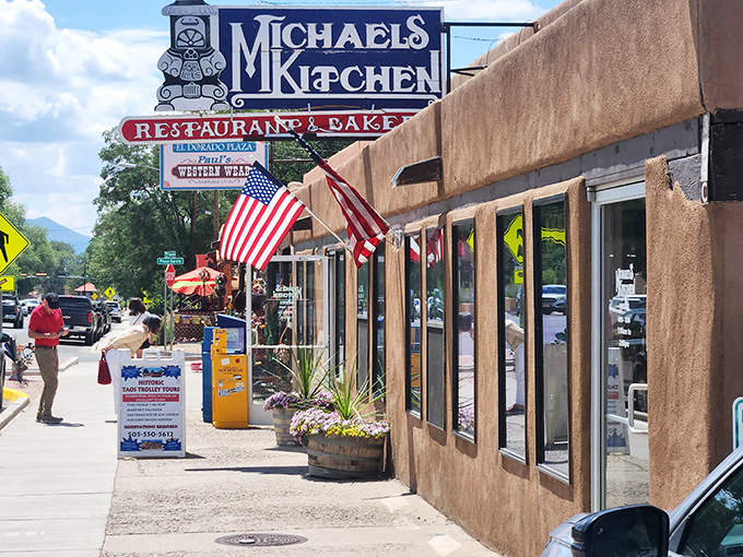The classic adobe exterior of Michael's Kitchen stands as a beacon of breakfast hope on Taos's main street, complete with American flags proudly waving.