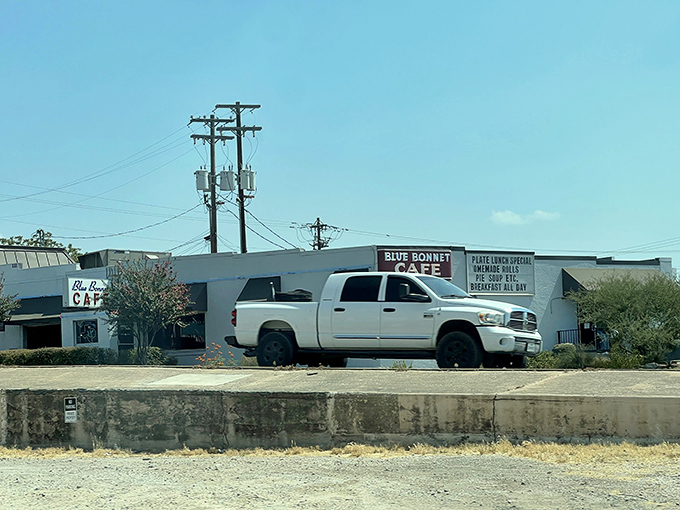 The unassuming white exterior of Blue Bonnet Cafe stands like a culinary lighthouse in Marble Falls, beckoning hungry travelers with promises of Texas-sized comfort.