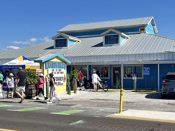 The iconic blue-roofed haven of Crabby Bill's beckons hungry beachgoers with its no-frills charm and promise of seafood treasures within.