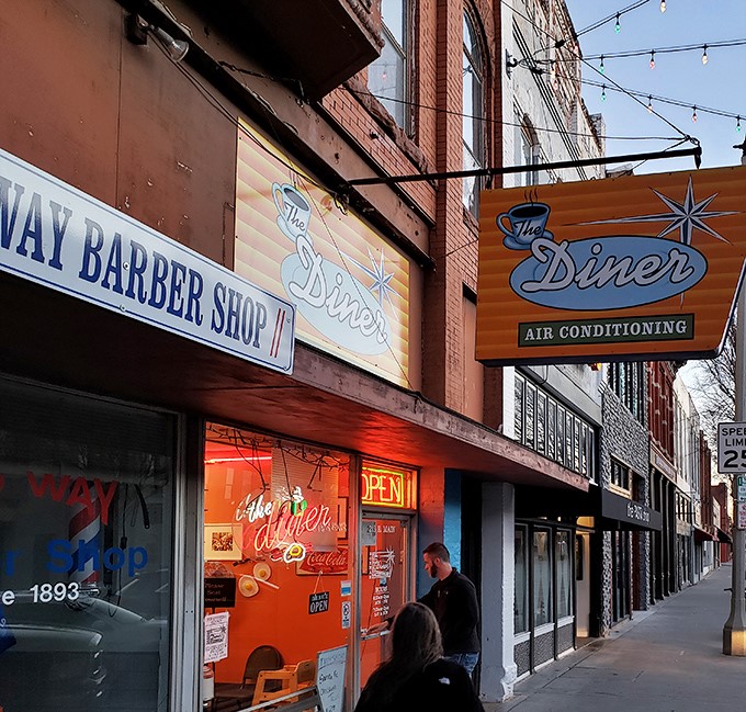 That iconic mid-century sign promising "AIR CONDITIONING" is like a beacon of breakfast hope on Norman's Main Street. Classic Americana at its finest.