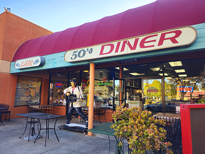 The iconic burgundy awning and Elvis statue welcome you to Classic 50's Diner, where nostalgia is always the first item on the menu.