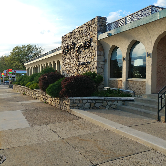 The stone facade of Country Club Diner stands like a mid-century modern time capsule, promising comfort food treasures within its arched entryway.