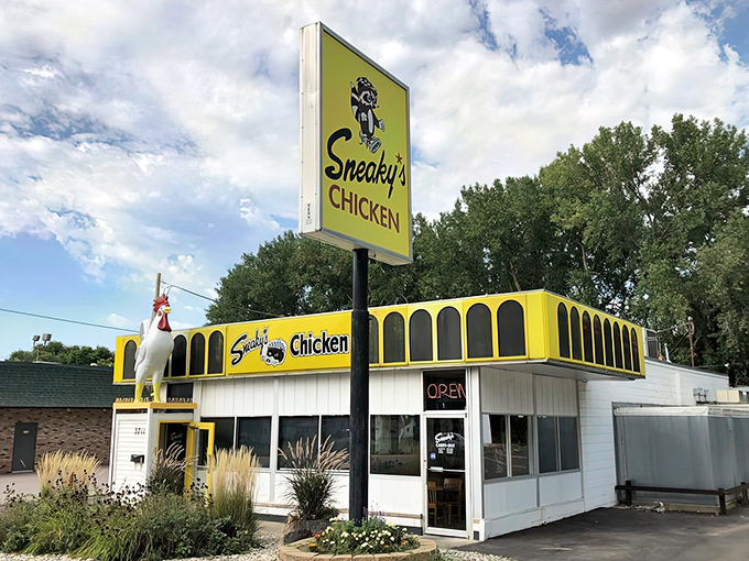 The yellow beacon of Sneaky's Chicken stands out against the Iowa sky like a delicious mirage, complete with a rooster sentinel keeping watch over fried chicken paradise.