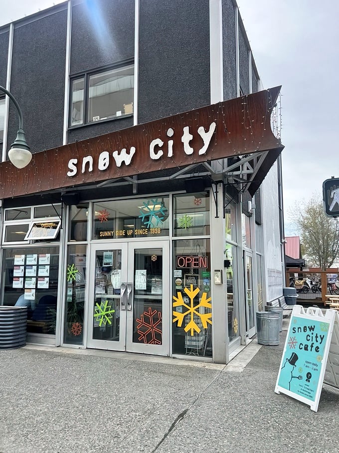 That iconic rusted sign has welcomed hungry Alaskans through countless snowstorms. The colorful snowflake decals hint at the playful spirit waiting inside.