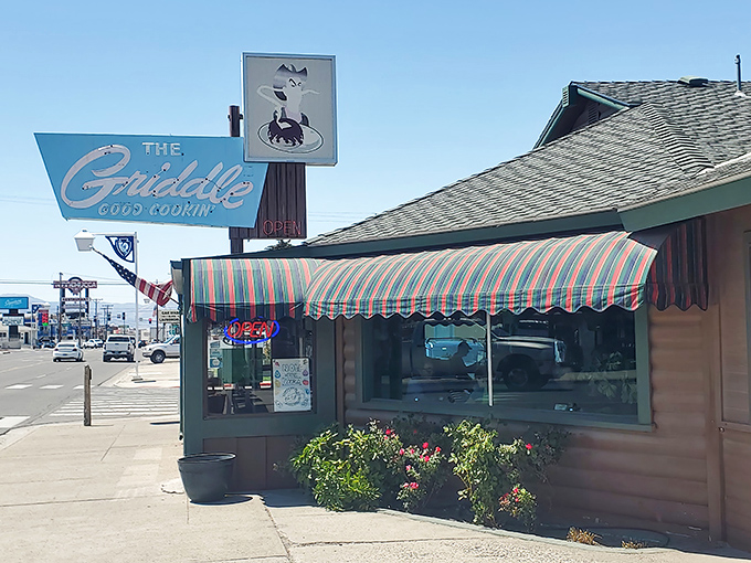 The blue vintage sign beckons like an old friend, promising "Good Cookin'" beneath Nevada's endless sky&mdash;a roadside oasis for hungry travelers.