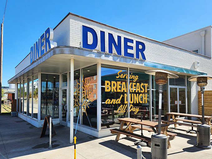 The classic blue "DINER" sign against white brick is like a beacon of breakfast hope in a world of complicated morning menus.