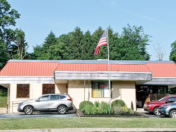 The classic red roof and American flag announce this roadside treasure like a beacon for hungry travelers seeking breakfast nirvana.