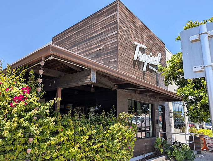 The rustic wooden facade of Tropical Smokehouse beckons like a smoke signal to BBQ lovers, promising Florida flavors with a side of sunshine.