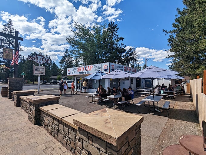 Under perfect Central Oregon skies, hungry patrons gather at Sno Cap's outdoor tables, waiting for those legendary burgers worth every minute.