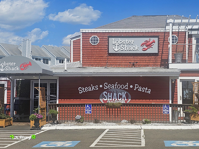 The iconic red-shingled exterior of The Lobster Shack stands as a beacon of seafood excellence along East Haven's shoreline, promising maritime delights within.