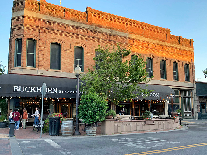 The historic brick facade of Buckhorn Steakhouse glows at sunset, promising carnivorous delights within this Winters landmark that's been drawing meat lovers for generations.