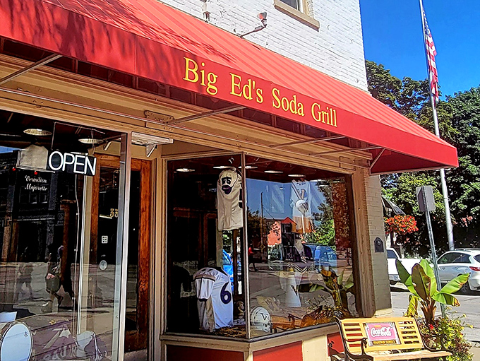 "Big Ed's Soda Grill" glows in golden letters against that classic red awning&mdash;a beacon for hungry travelers and nostalgic locals alike.