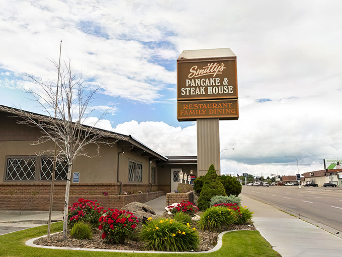 Smitty's iconic roadside sign welcomes hungry travelers like a beacon of breakfast hope. The landscaped entrance promises comfort food that's worth pulling over for.