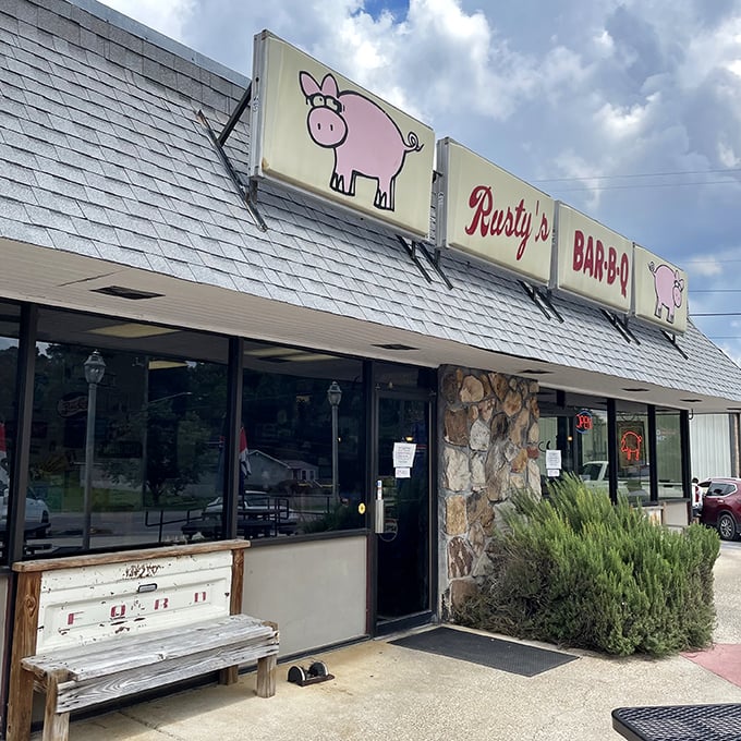 The cheerful pig mascots flanking Rusty's sign are like barbecue ambassadors, welcoming hungry travelers with a promise of smoky delights within.