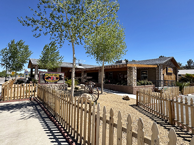 The desert oasis of barbecue dreams. Smokin' J's rustic stone exterior and charming yellow picket fence promise smoky delights within.