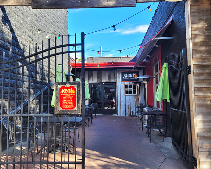 The purple-hued entrance to Meat BBQ beckons like a smoky siren call, with colorful string lights promising delicious adventures within.