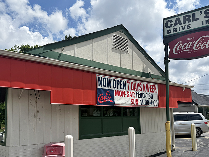 The unassuming red and white exterior of Carl's Drive-In stands as a time capsule on Manchester Road, promising nostalgic flavors that have survived decades of food trends.