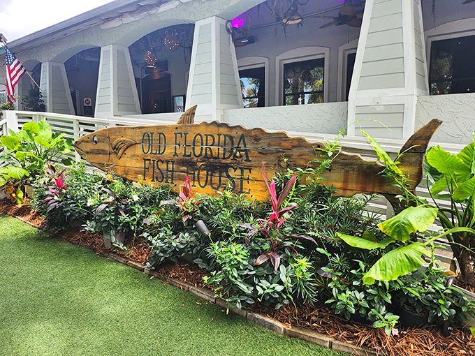 The iconic fish-shaped sign welcomes you like an old friend. Lush tropical plants frame this wooden masterpiece, promising seafood adventures ahead.