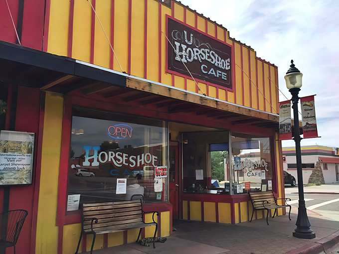 The vibrant red and yellow exterior of Horseshoe Cafe stands out like a beacon of breakfast hope on Wickenburg's main street, welcoming hungry travelers since 1938.