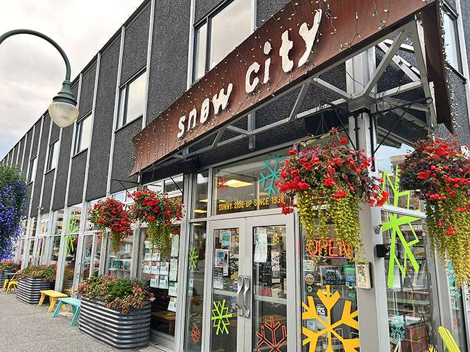 The rustic charm of Snow City Cafe's exterior, with its weathered metal sign and colorful hanging baskets, promises a breakfast experience worth the inevitable wait.