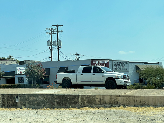 The unassuming white exterior of Blue Bonnet Cafe stands like a culinary lighthouse in Marble Falls, beckoning hungry travelers with promises of Texas-sized comfort.