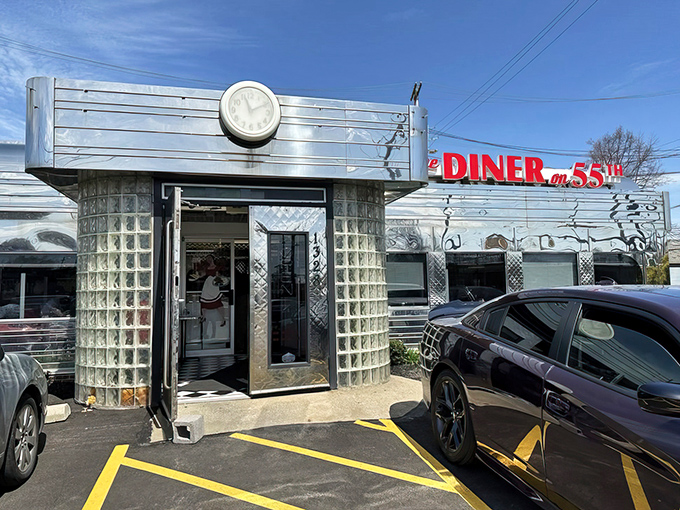 The gleaming stainless steel exterior of Diner on 55th stands like a time capsule of Americana, complete with that iconic clock saying "it's always time for breakfast."