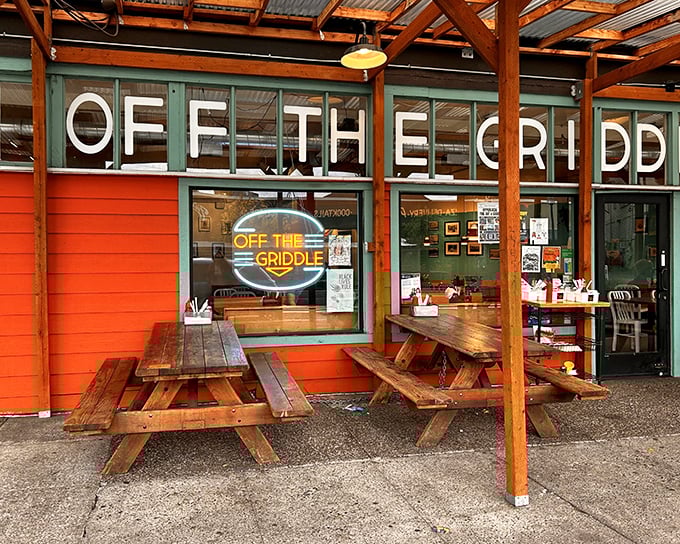 The vibrant orange exterior of Off The Griddle beckons like a culinary lighthouse, complete with rustic picnic tables for Portland's rare sunny days.