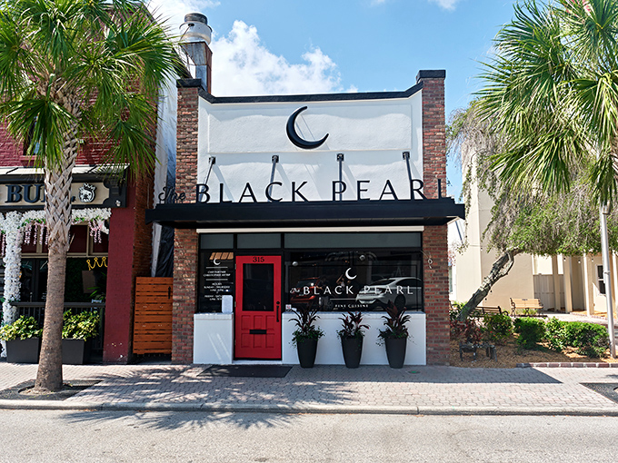 Framed by Florida's signature palm trees, The Black Pearl's elegant storefront brings a touch of metropolitan sophistication to Dunedin's charming streetscape &ndash; fine dining with a coastal backdrop.