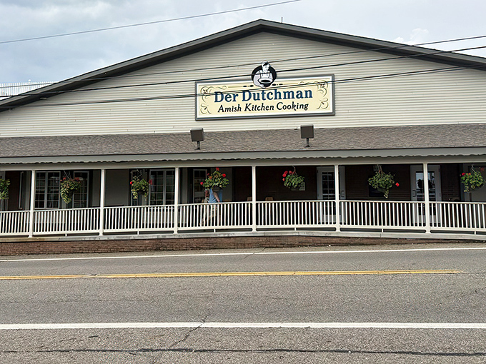 The welcoming front porch of Der Dutchman beckons like a grandmother's hug, complete with hanging flower baskets that could win garden club competitions.