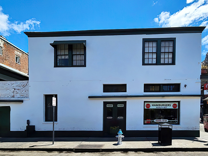The unassuming white exterior of Clover Grill stands like a culinary lighthouse on Bourbon Street, promising salvation to hungry souls at any hour.
