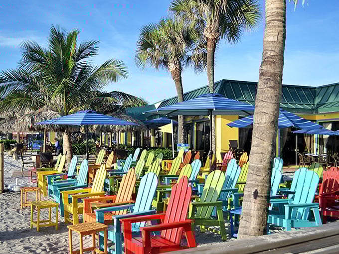 A rainbow armada of Adirondack chairs stands at attention, ready for beachgoers to collapse into their colorful embrace after a hard day of vacation.