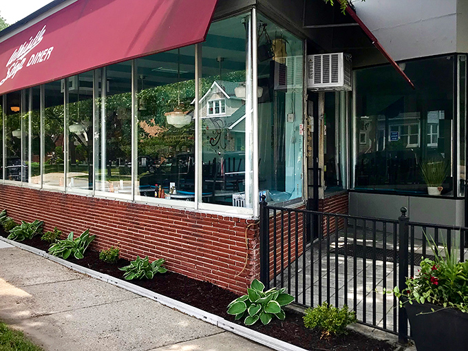 The iconic red awning of Whistle Stop Diner stands out on Woodward Avenue like a beacon for breakfast pilgrims. Neatly landscaped hostas add a homey touch.