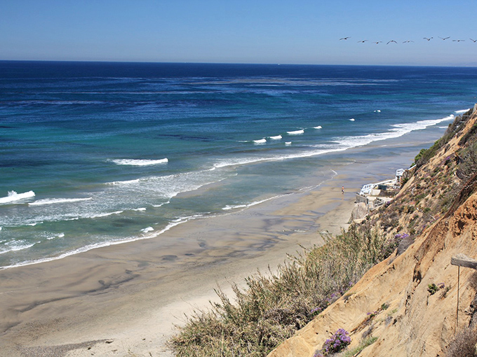Nature's own infinity pool where the Pacific meets pristine shoreline, with sandstone sentinels standing guard over this hidden slice of paradise.