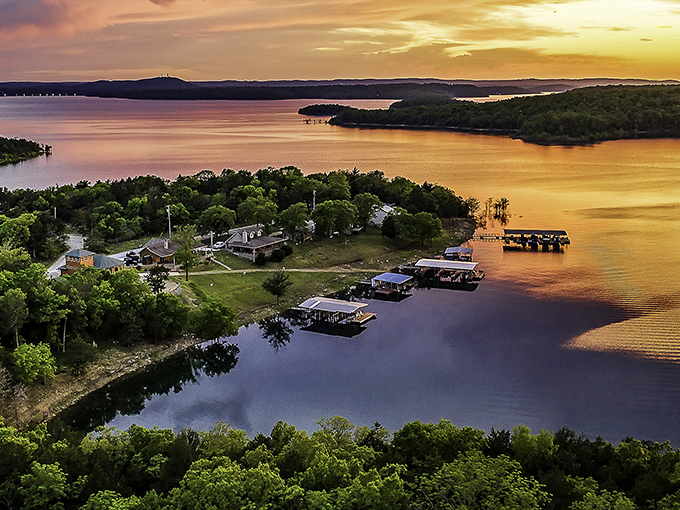Sunset transforms Bull Shoals Lake into liquid gold, where docks wait patiently for tomorrow's fishing stories. Nature's light show happens daily, no tickets required.