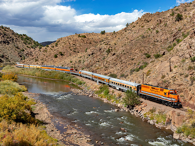 The iconic orange locomotive snakes alongside the Arkansas River, a perfect example of how Colorado casually combines engineering marvels with jaw-dropping natural beauty.