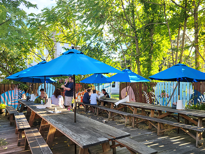 Summer paradise found! Blue Pit's dog-friendly patio offers shaded wooden picnic tables under bright blue umbrellas&mdash;the perfect setting for barbecue bliss on a sunny Baltimore afternoon