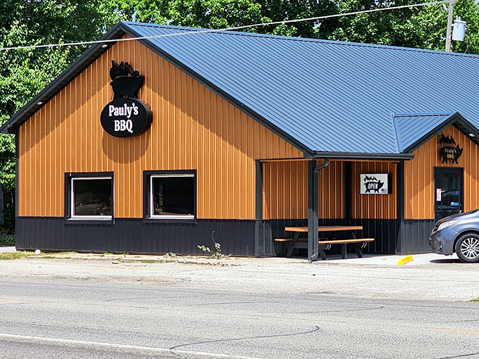 The unassuming wooden exterior of Pauly's BBQ in Arthur might fool you, but that blue metal roof shelters some serious smoke magic inside.