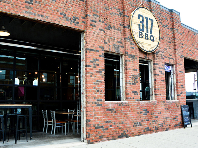 That circular wooden sign might as well say "Meat Paradise Ahead." The rustic logo promises smoky treasures within these brick walls.