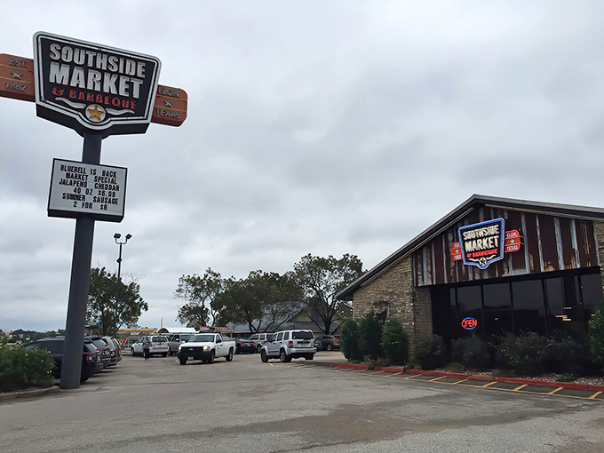 The iconic Southside Market sign stands tall against the Texas sky, beckoning hungry travelers like a smoky lighthouse for barbecue pilgrims.
