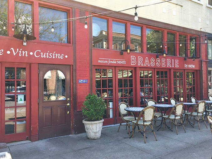 The iconic burgundy fa&ccedil;ade of Brasserie by Niche beckons from the sidewalk, those blue-striped bistro chairs practically whispering, "Bonjour, hungry traveler!"